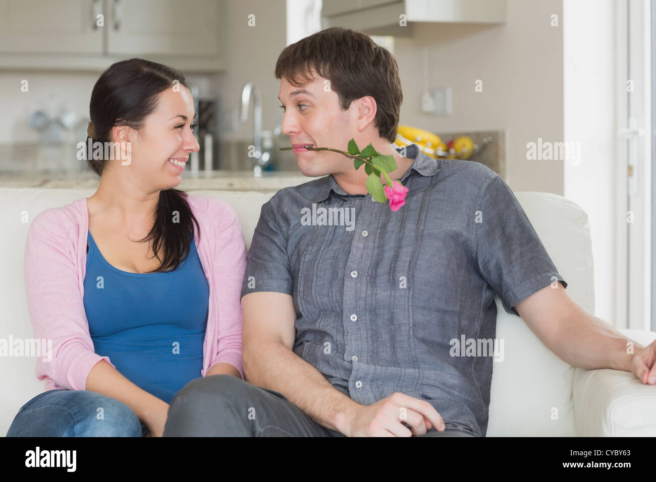 Man presenting a flower to the woman in his teeth Stock Photo - Alamy