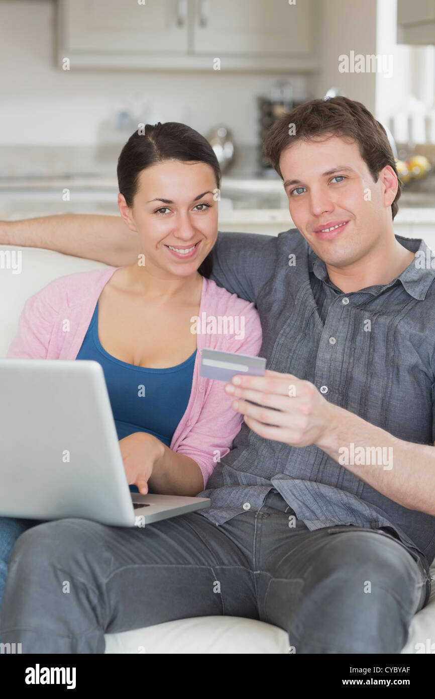 Two people using the laptop on the couch Stock Photo - Alamy