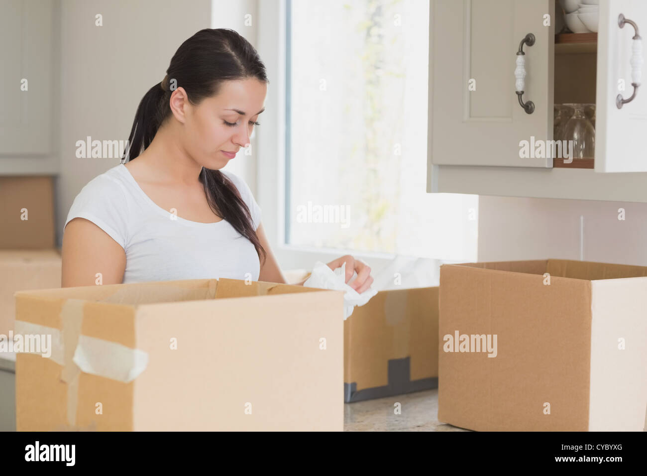 Woman unpacking in kitchen Stock Photo - Alamy