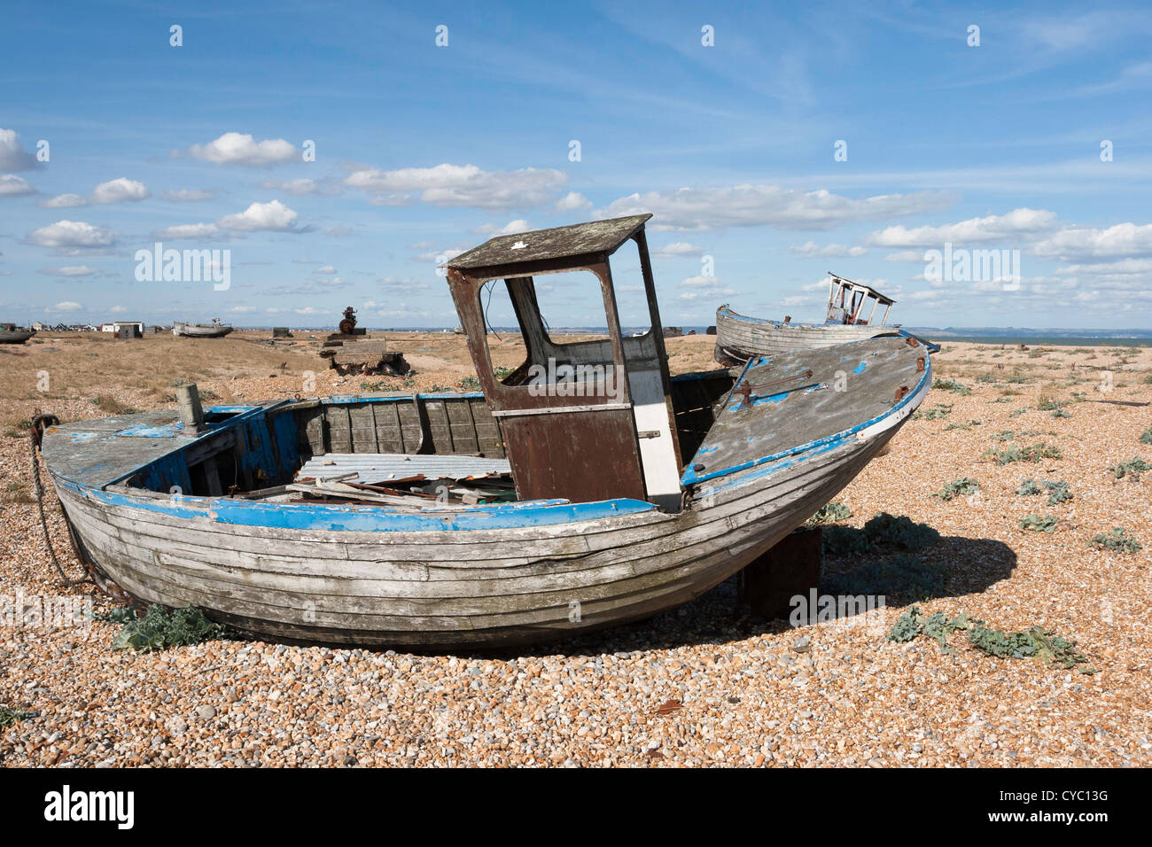 Old fishing boat marooned on the shingle beach at Dungeness in Kent ...
