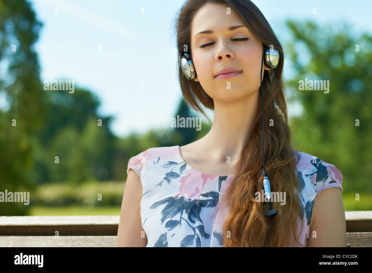 Beauty female model listening music in the park Stock Photo - Alamy