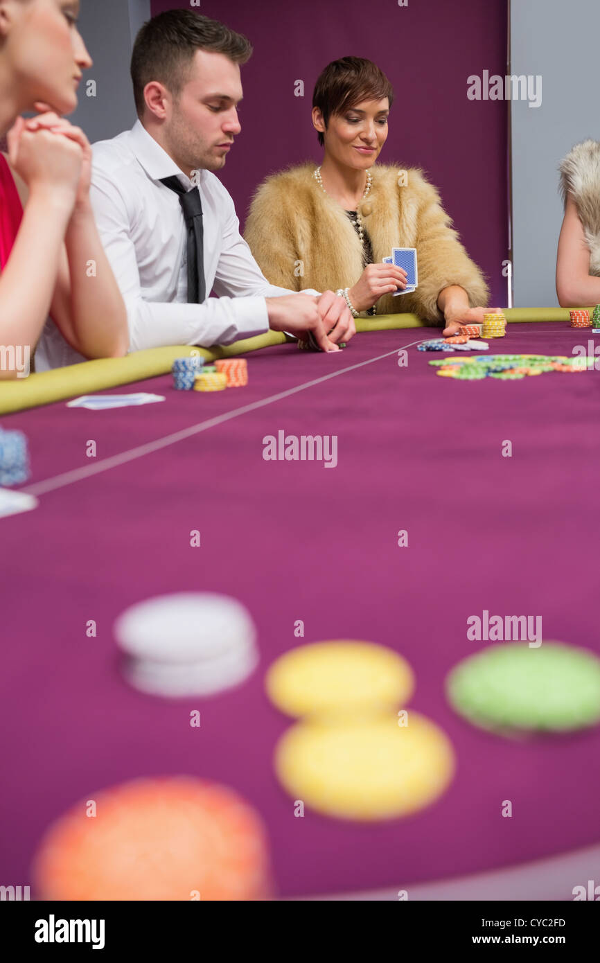 Woman placing bet at poker game Stock Photo - Alamy