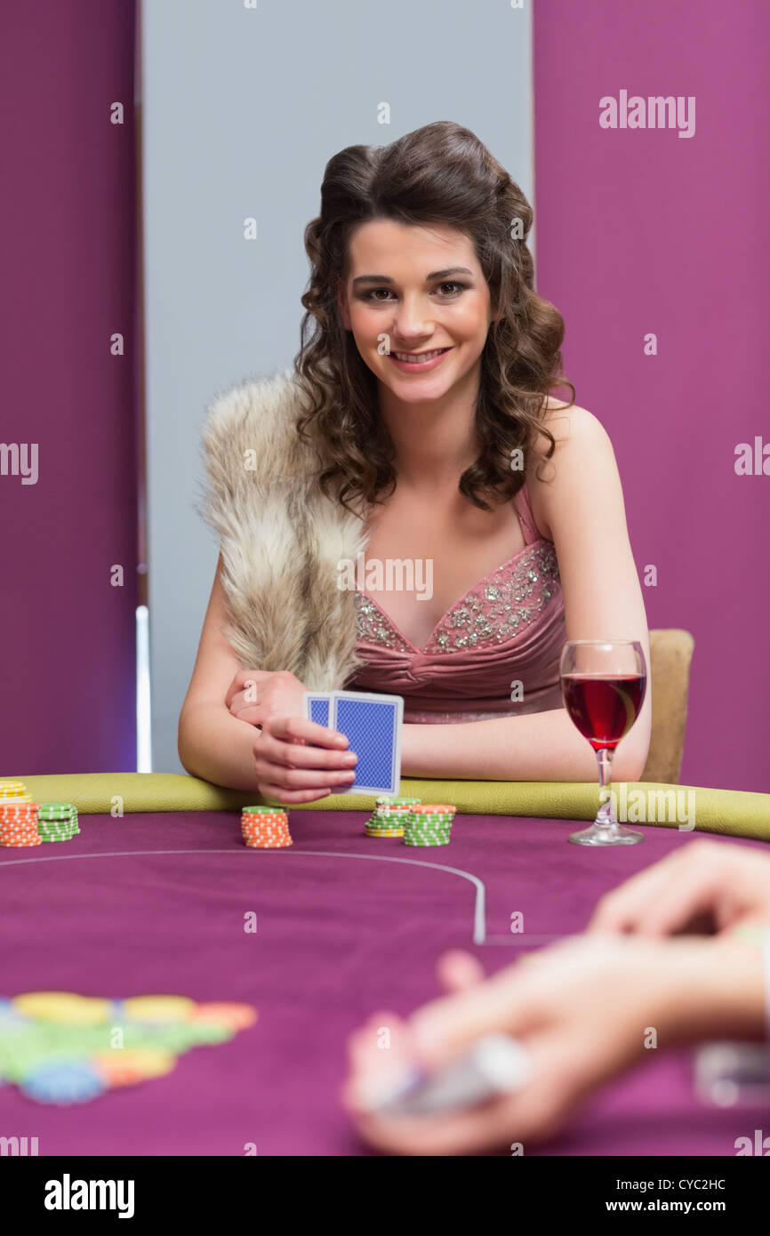 Woman sitting at the table smiling holding cards Stock Photo - Alamy