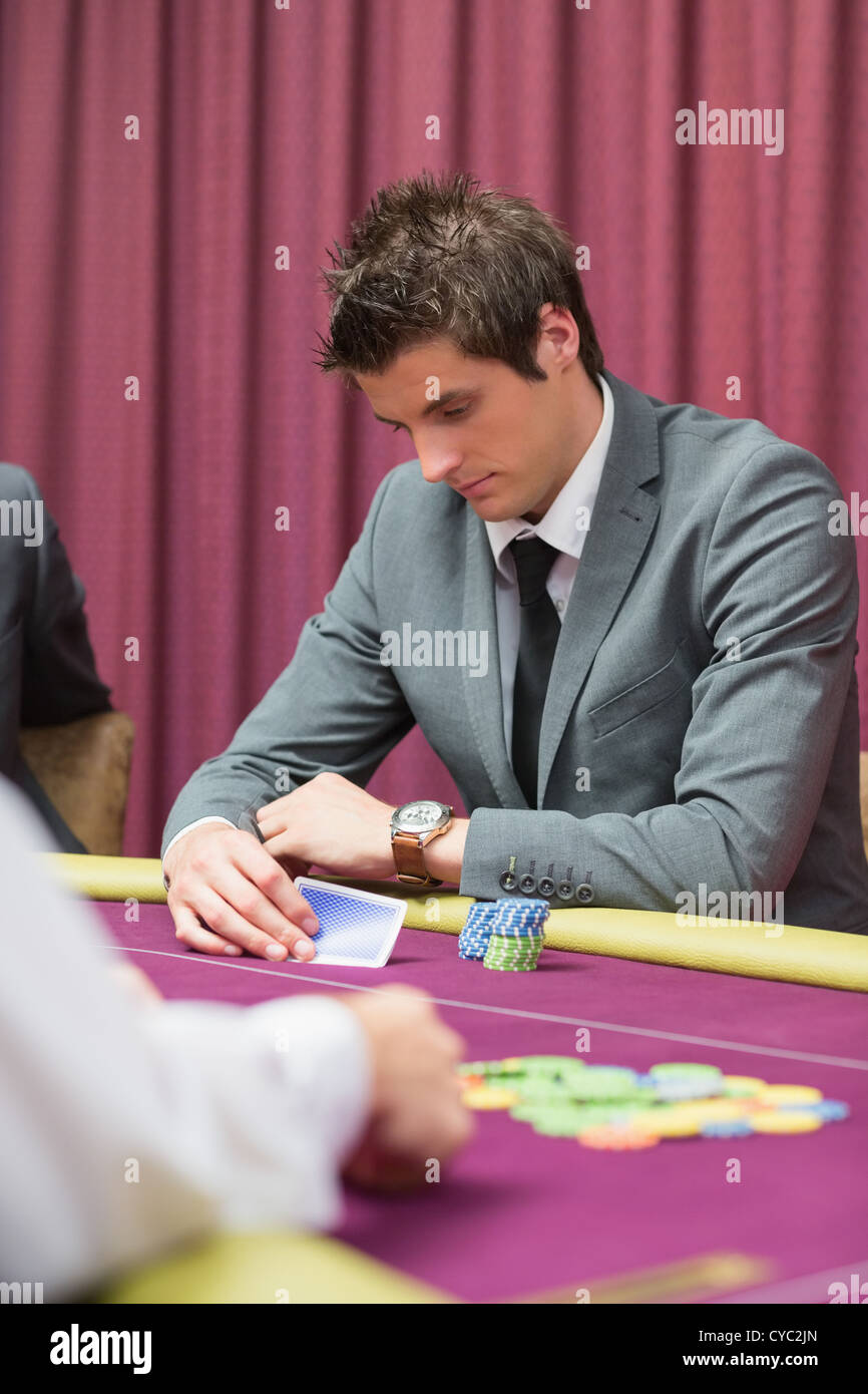 Man looking at his cards in poker game Stock Photo - Alamy