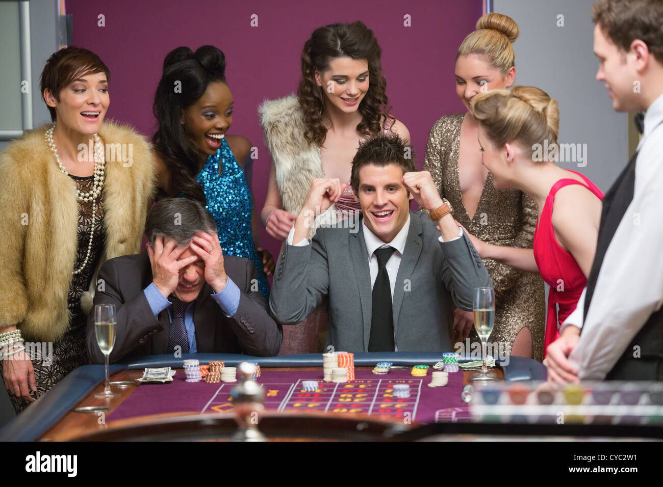 Man winning as another is losing at roulette table Stock Photo - Alamy