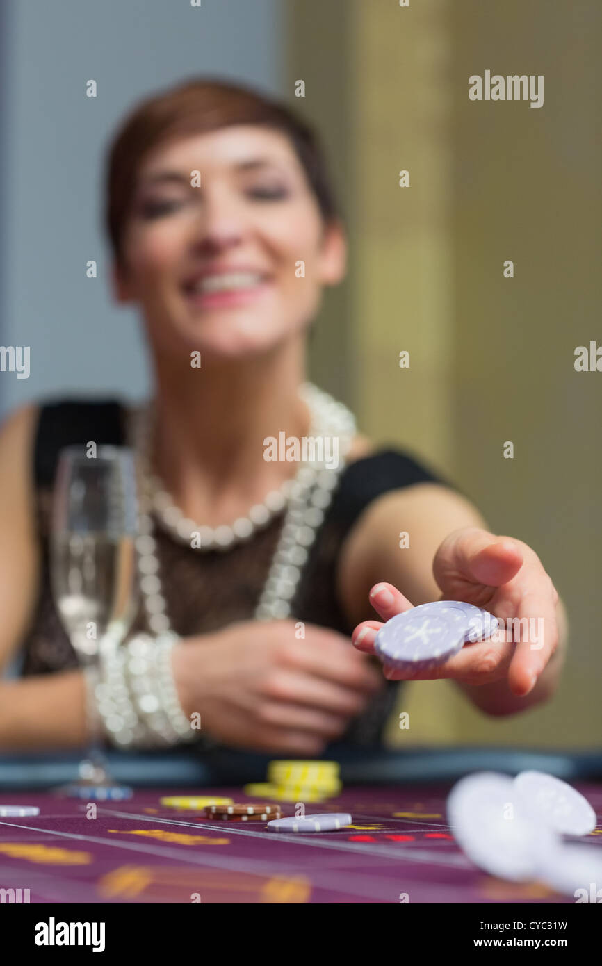 Woman throwing chip on roulette table Stock Photo - Alamy