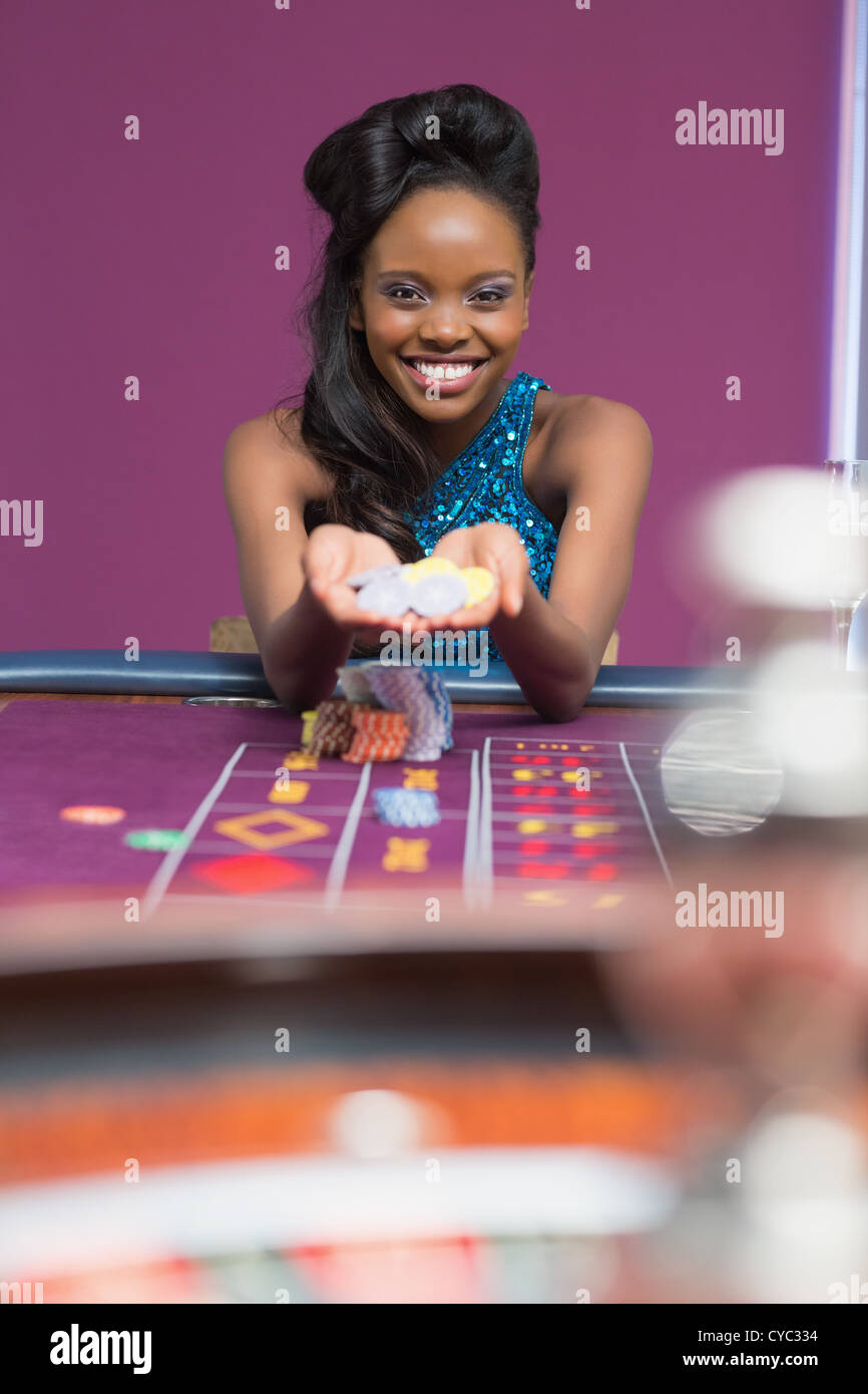 Woman smiling holding up chips Stock Photo - Alamy