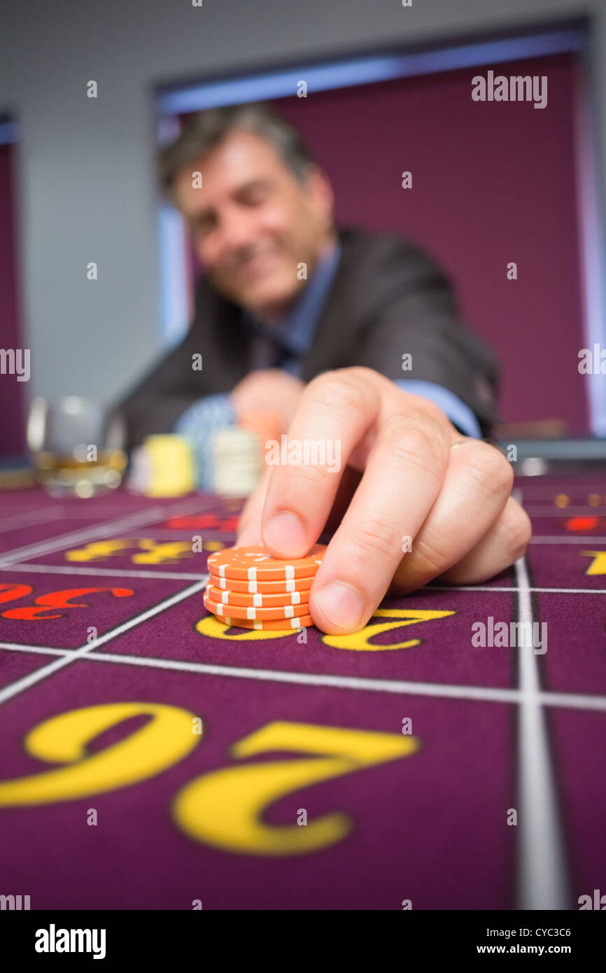 Man placing roulette bet Stock Photo - Alamy