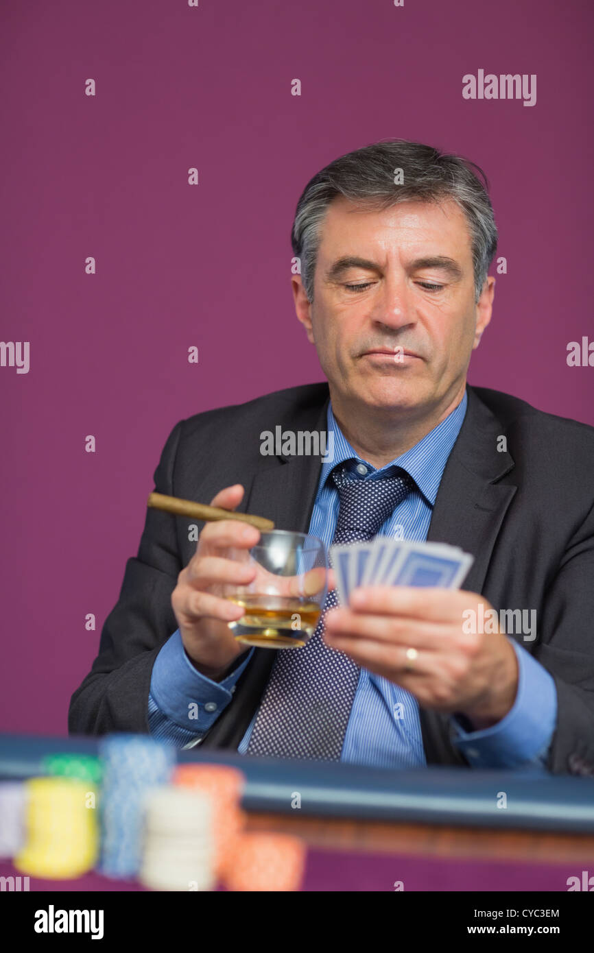 Man sitting looking at his cards Stock Photo - Alamy