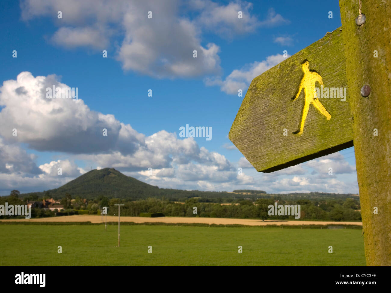 Wooden public footpath sign, blue sky, fluffy clouds and the Wrekin in ...