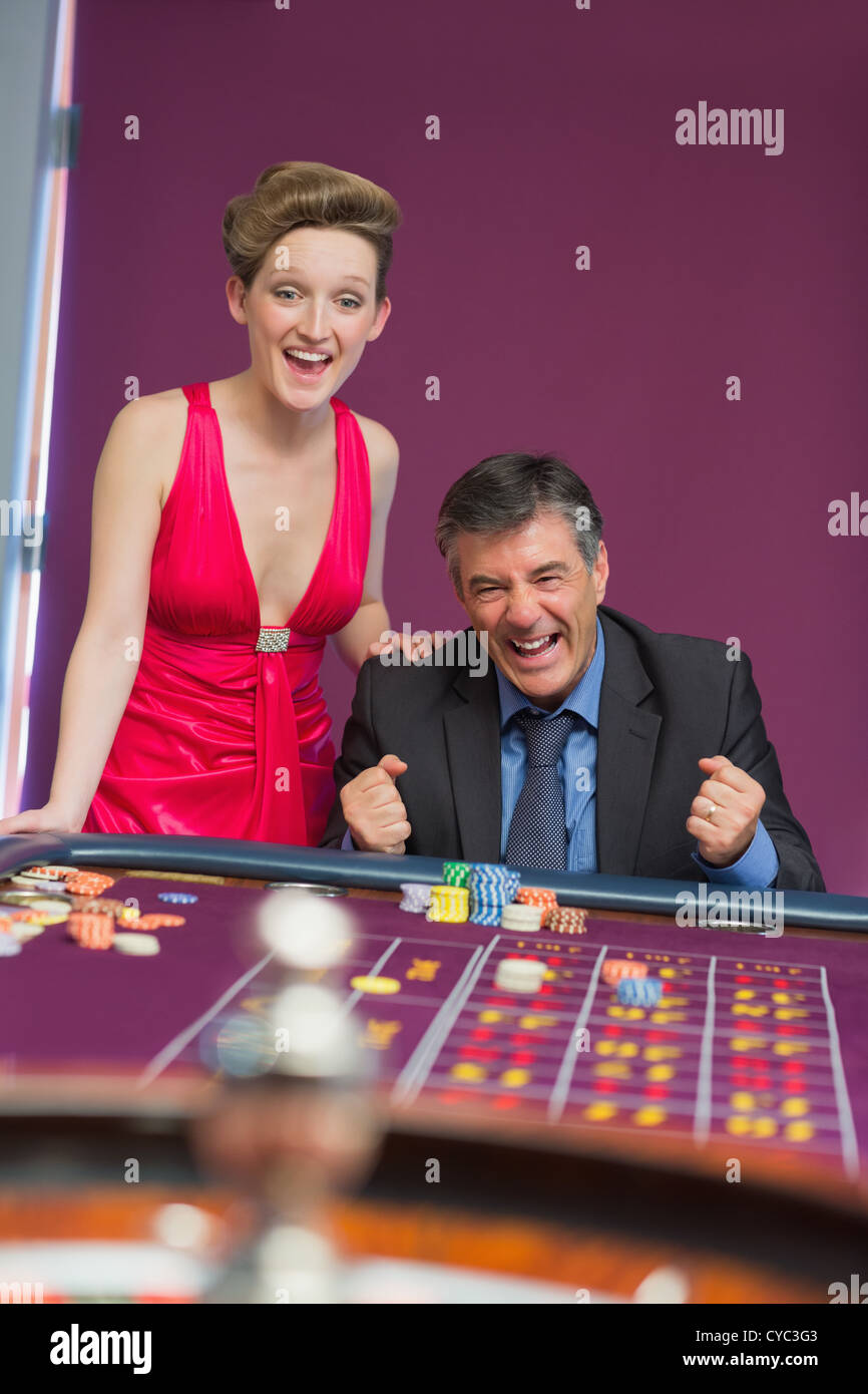 Man and woman cheering at roulette table Stock Photo - Alamy