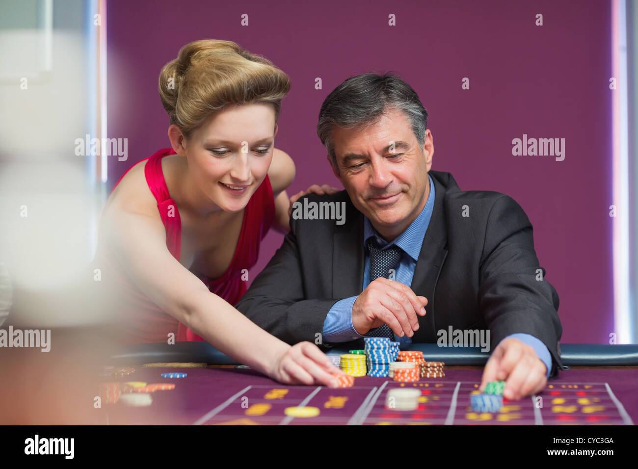 Man and woman placing bets Stock Photo - Alamy
