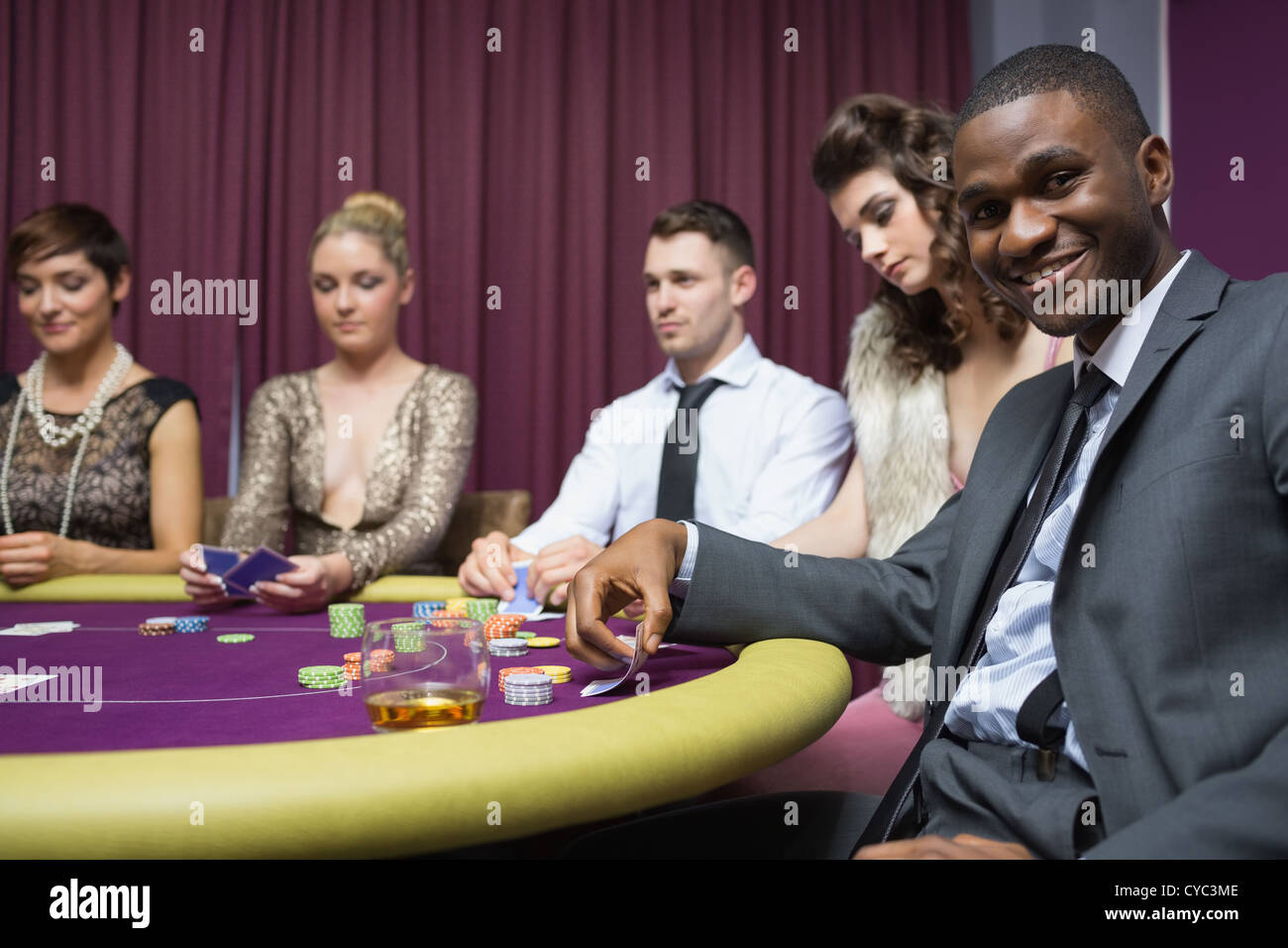 Man looking up from poker game and smiling Stock Photo - Alamy
