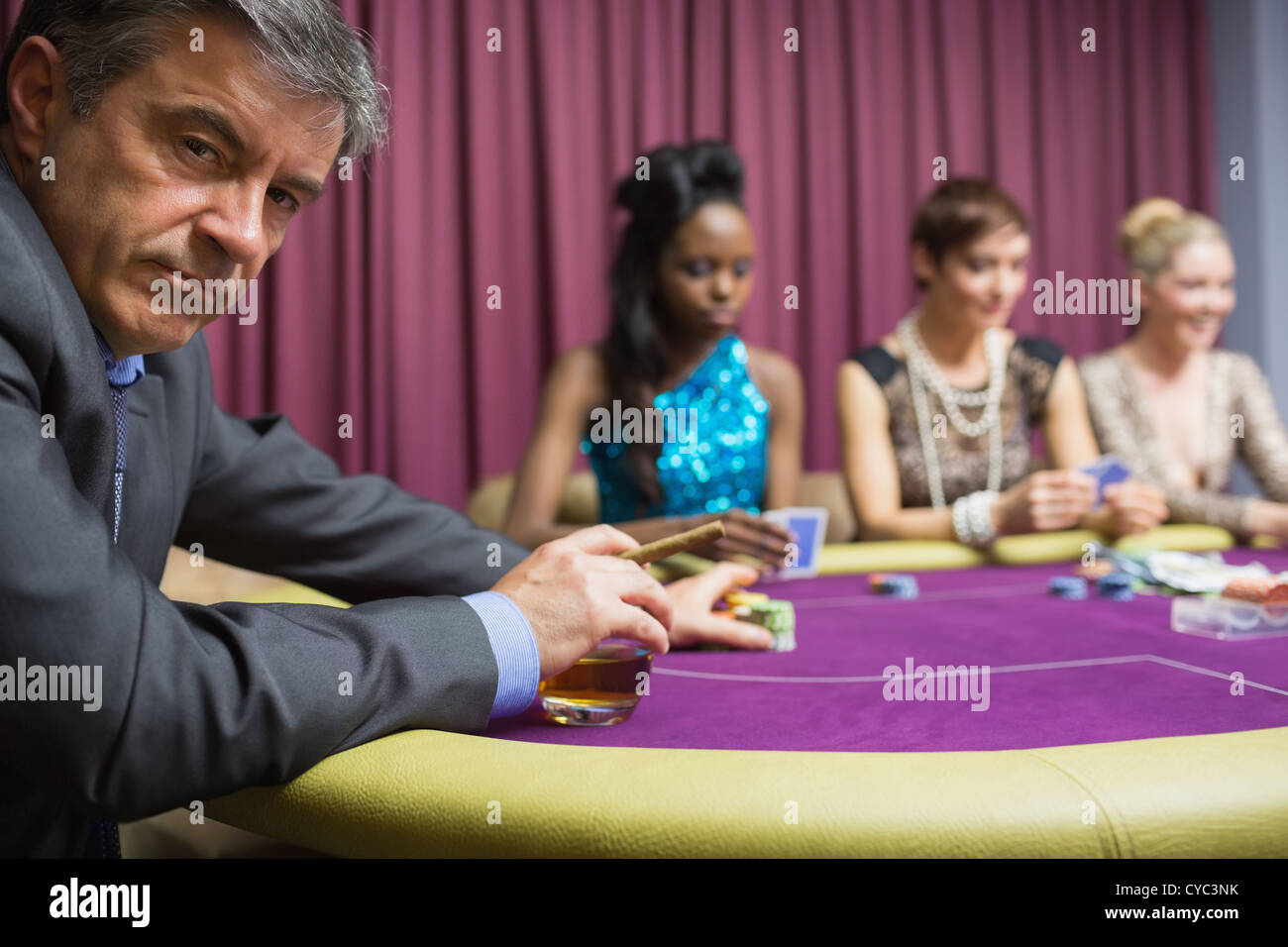 Man with whiskey looking angry at poker game Stock Photo - Alamy