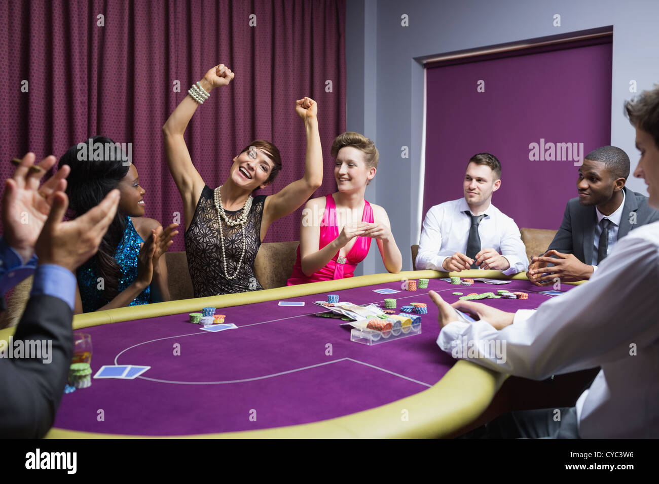 People cheering at poker table Stock Photo - Alamy
