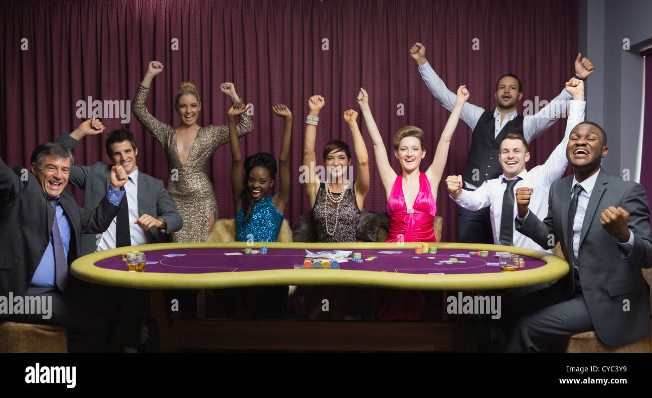 Cheering group at poker table Stock Photo - Alamy