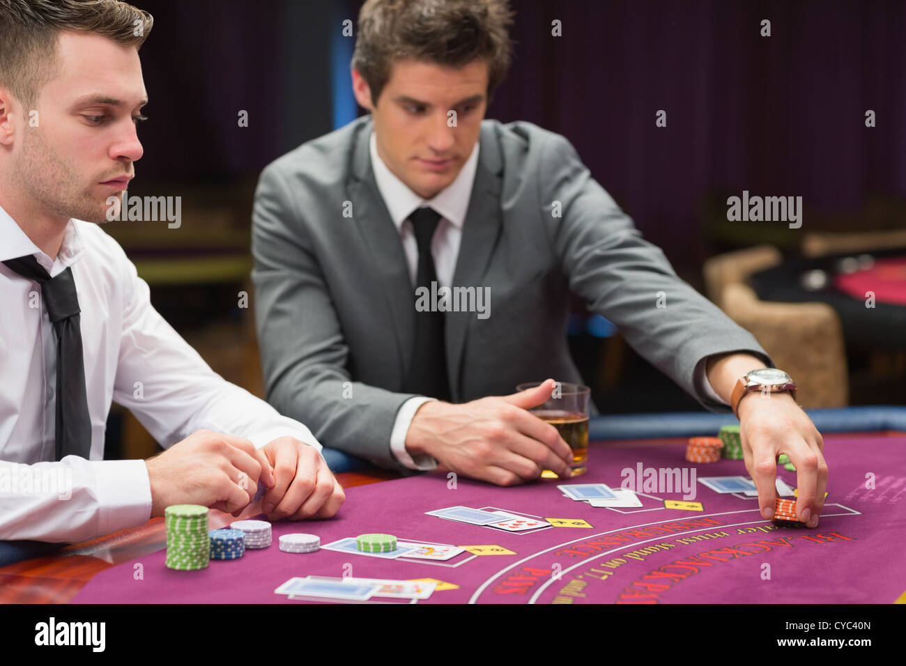 Men placing bets at poker game Stock Photo - Alamy