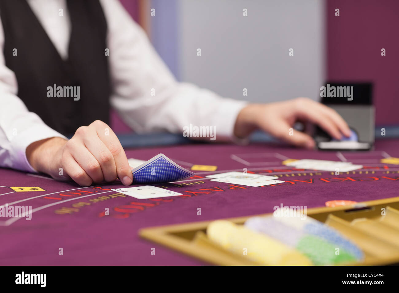 Dealer distributing cards at table Stock Photo - Alamy