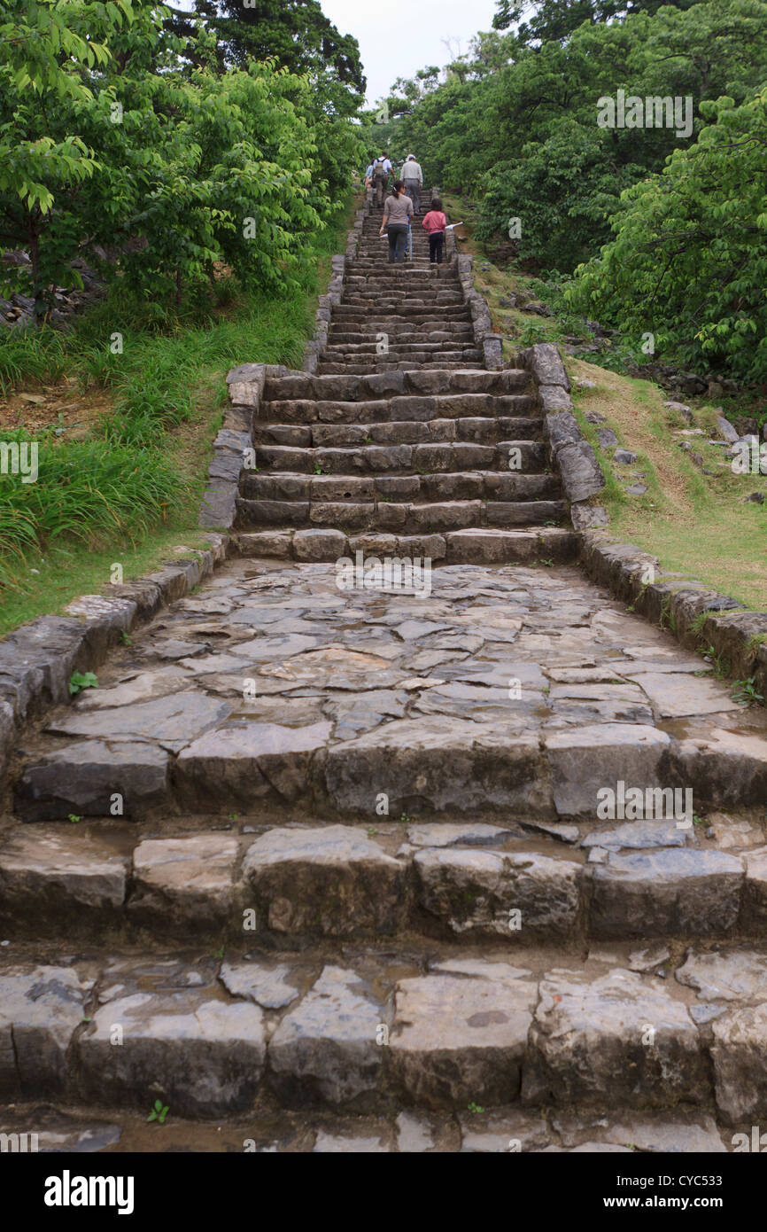 Tourists climb the stairs to the ruins of the ancient Okinawan castle ...