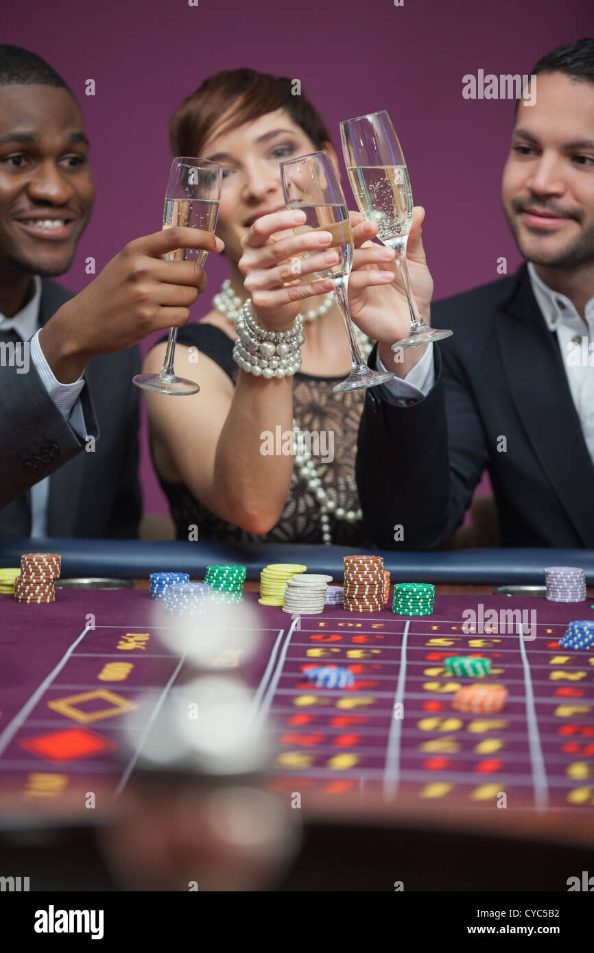 Three people toasting at roulette table Stock Photo - Alamy