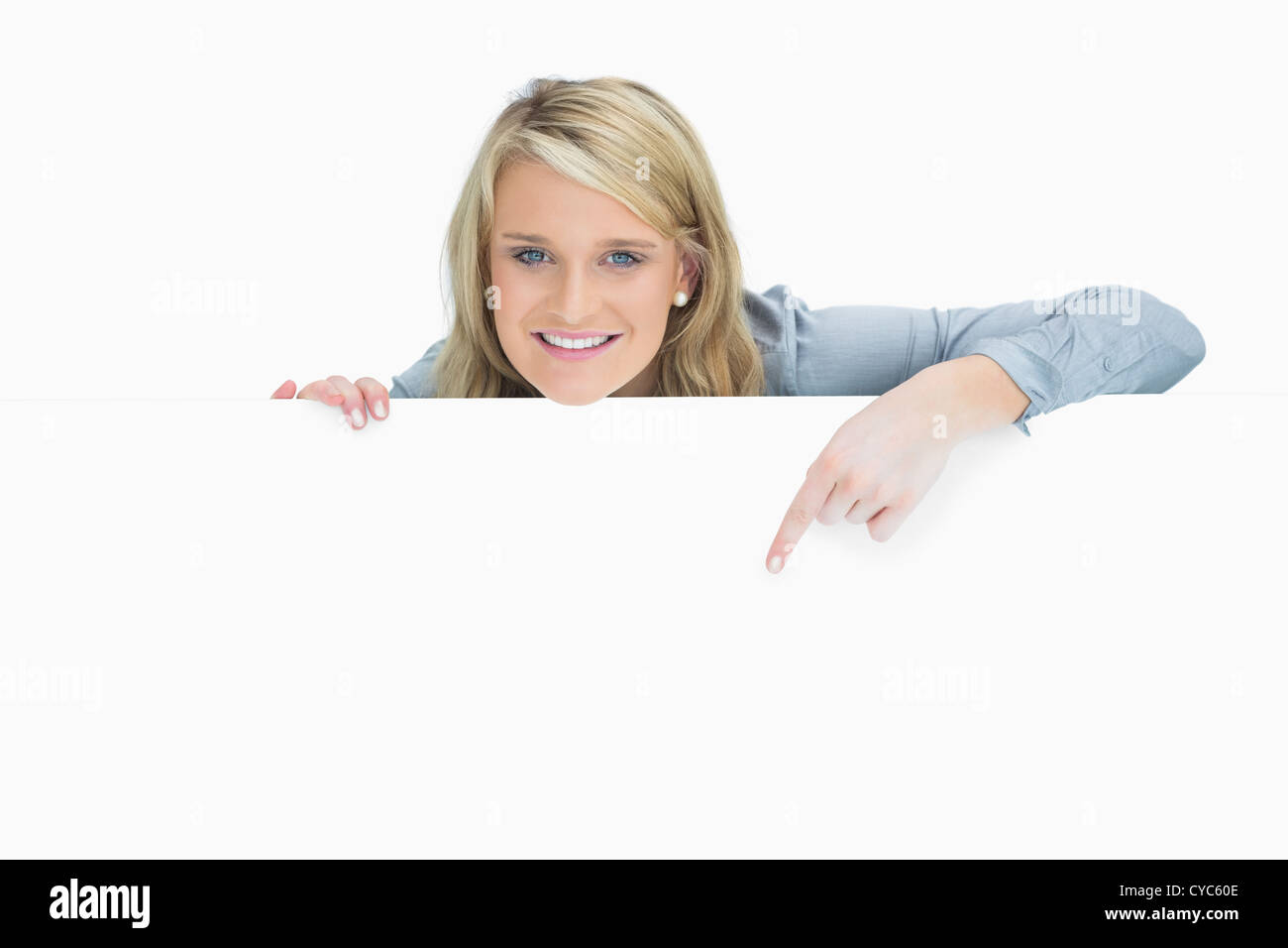 Cheerful woman pointing down Stock Photo - Alamy