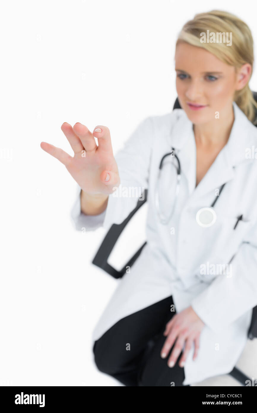Sitting doctor touching something Stock Photo - Alamy