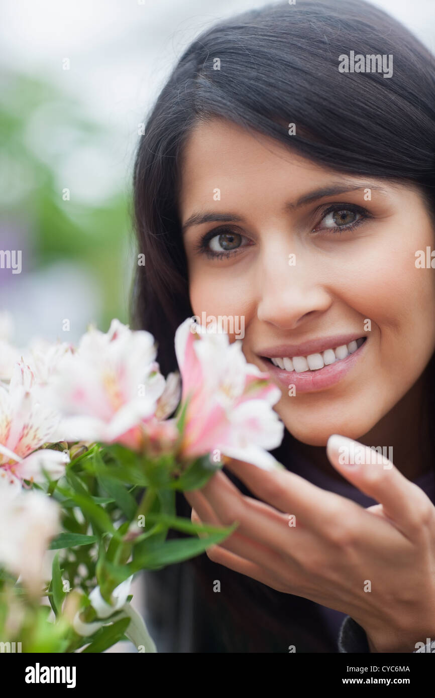 Smiling woman smelling a flower Stock Photo - Alamy