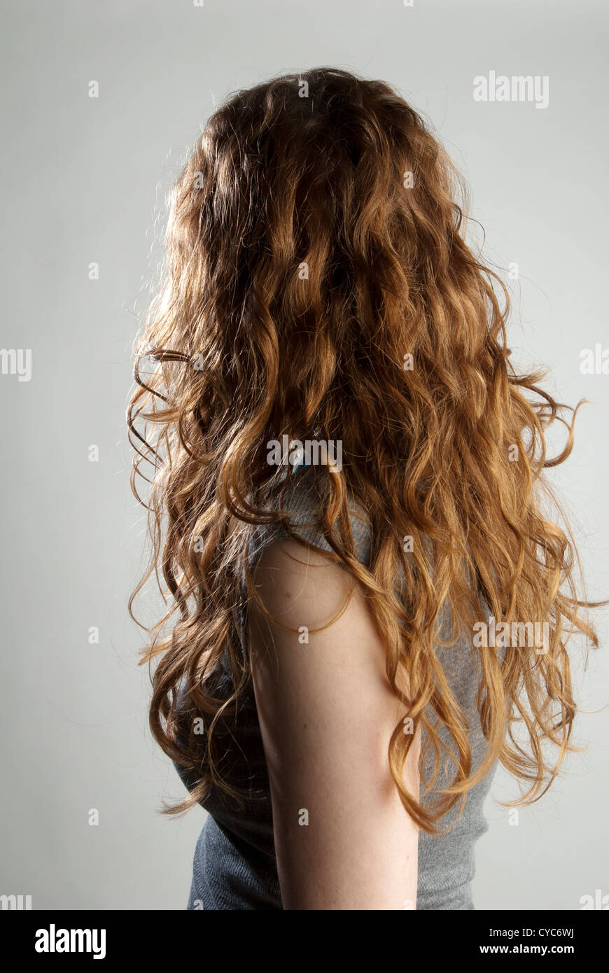 Head and shoulders portrait of woman with back turned, long red hair ...