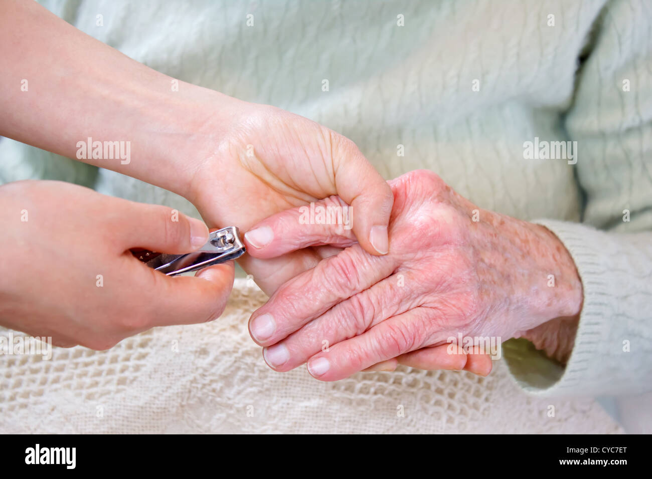 Senior and young women's hands clipping nails Stock Photo - Alamy