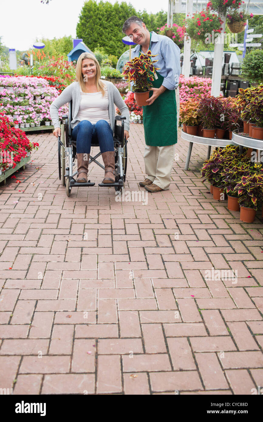 Garden center employee and woman in wheelchair Stock Photo - Alamy