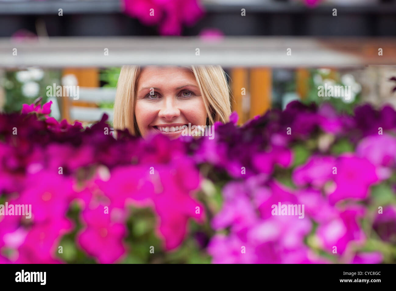 Woman looking through flower shelf Stock Photo - Alamy