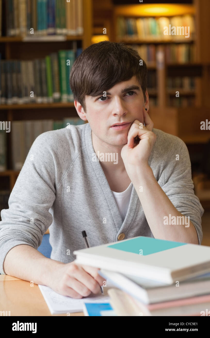 Man sitting at library desk and thinking Stock Photo - Alamy