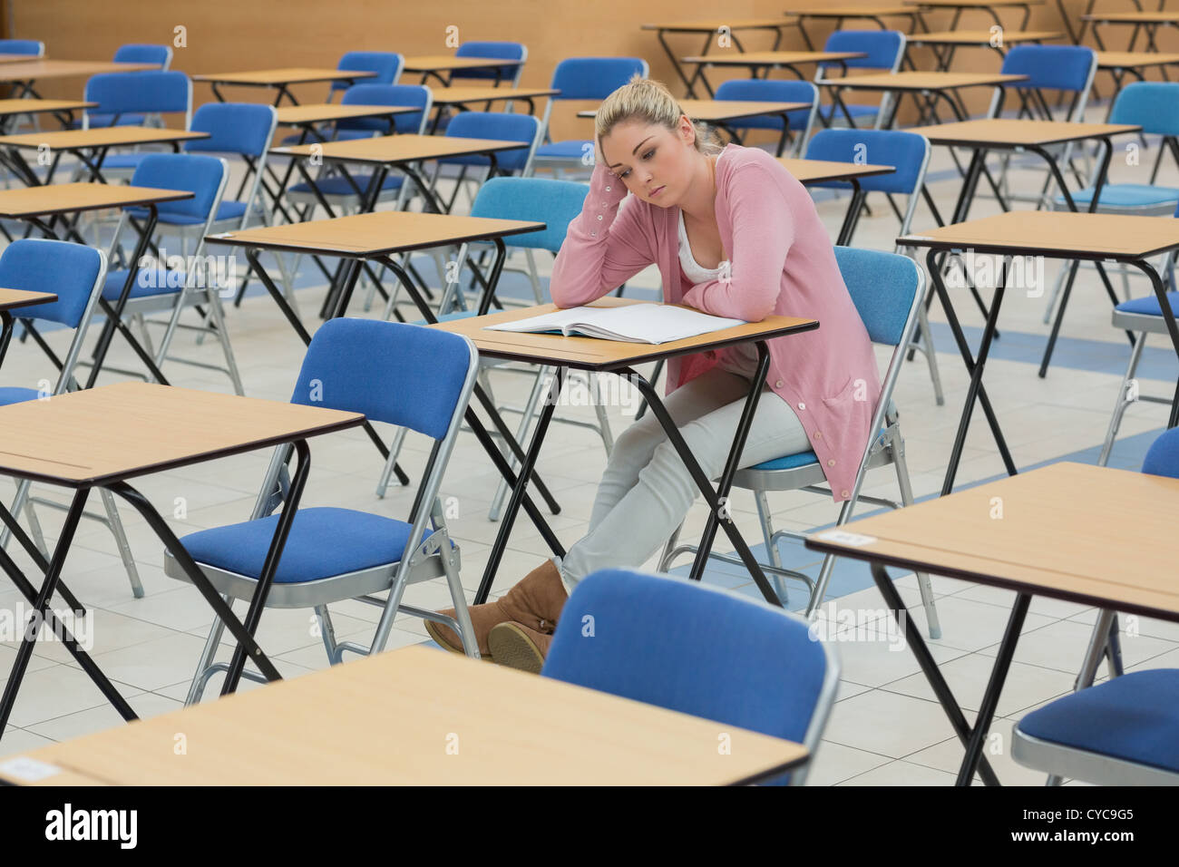 Student sitting at desk thinking Stock Photo - Alamy