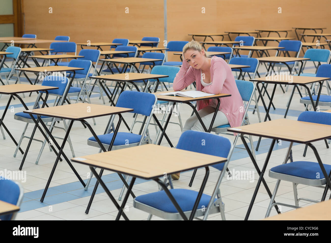 Student sitting at desk in empty exam hall Stock Photo - Alamy