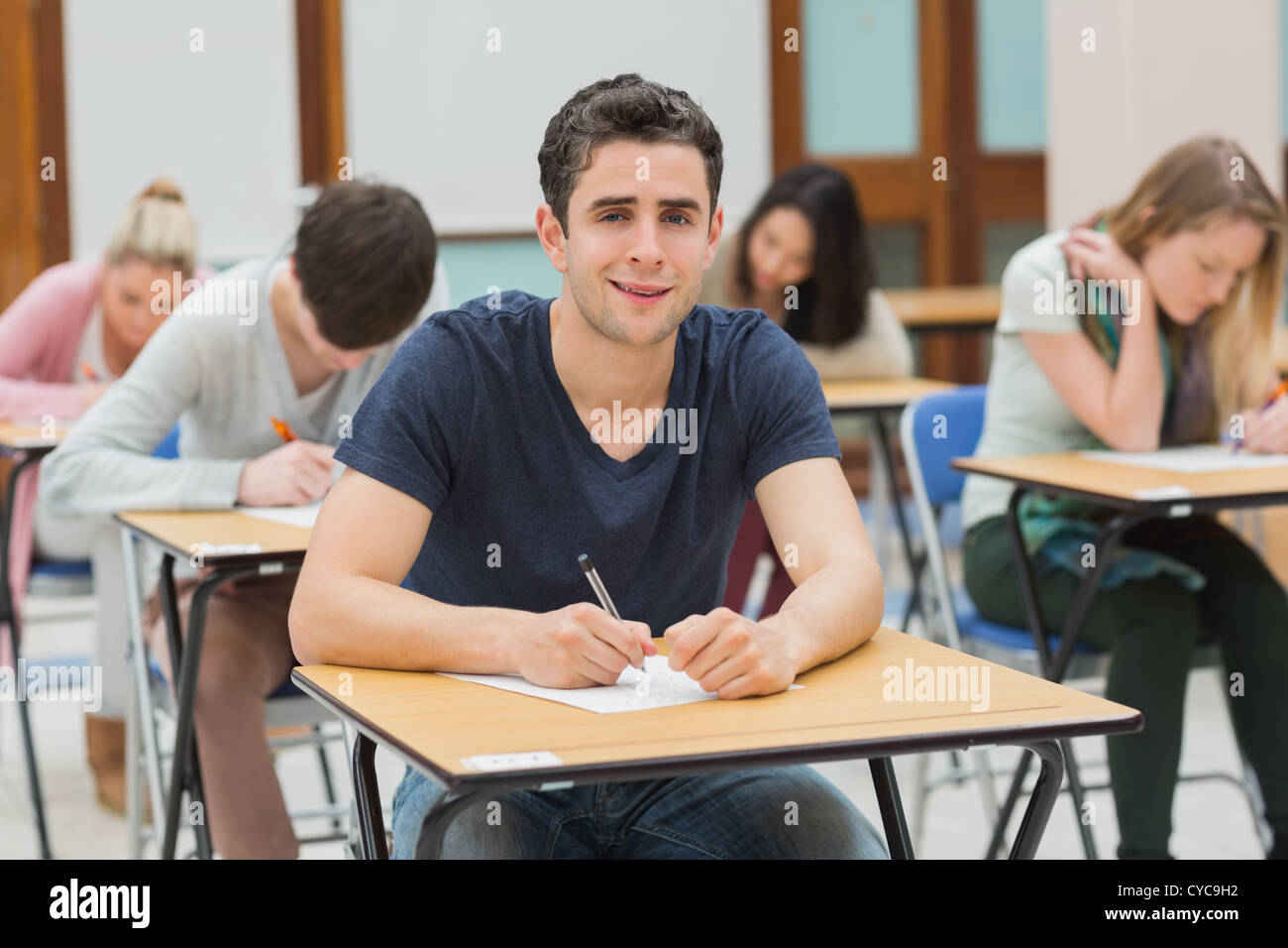 Man looking up from exam and smiling Stock Photo - Alamy