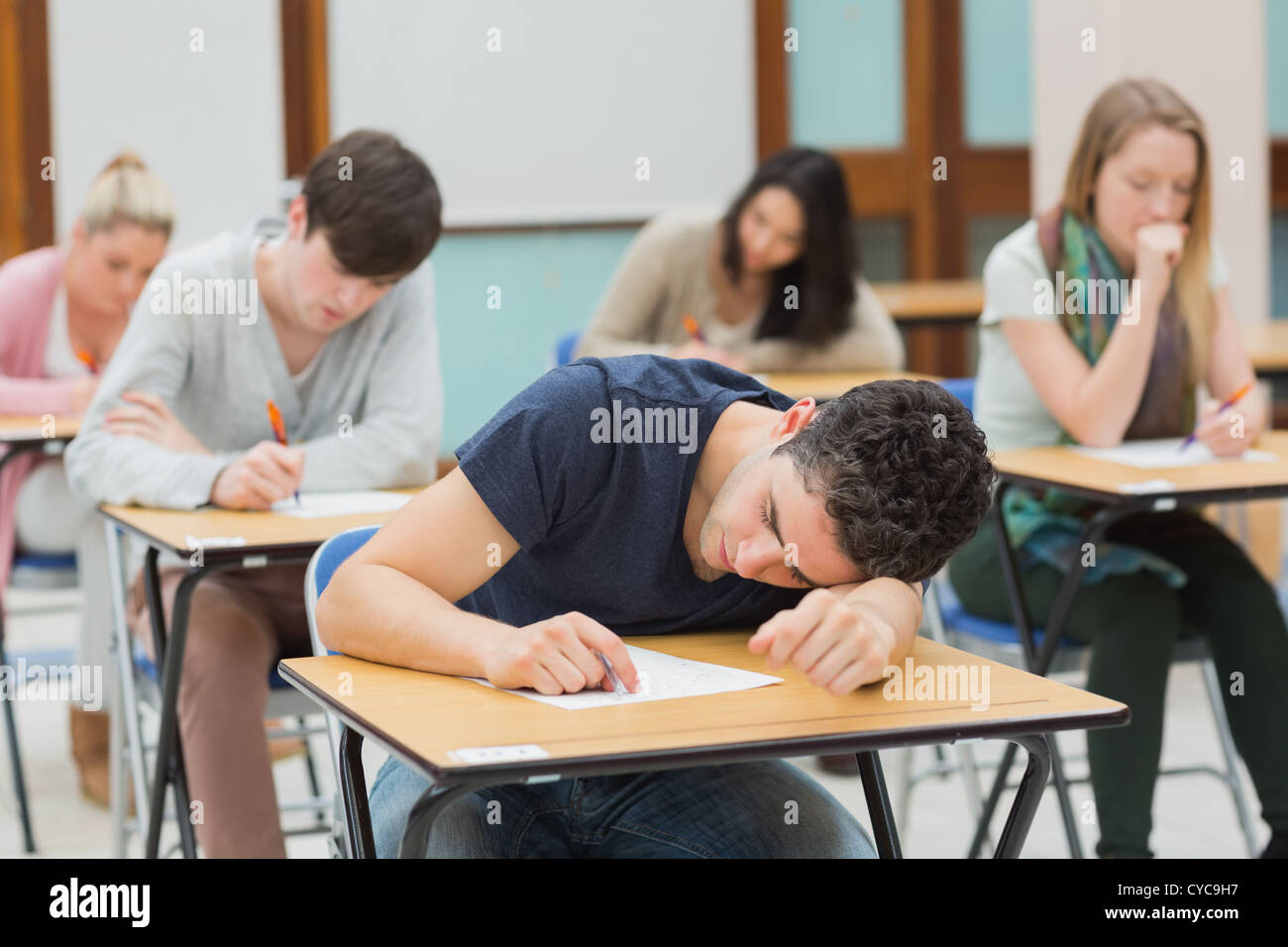 Man sleeping in exam hall Stock Photo - Alamy