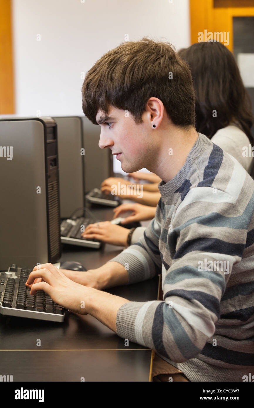 Man sitting at computer desk typing Stock Photo - Alamy