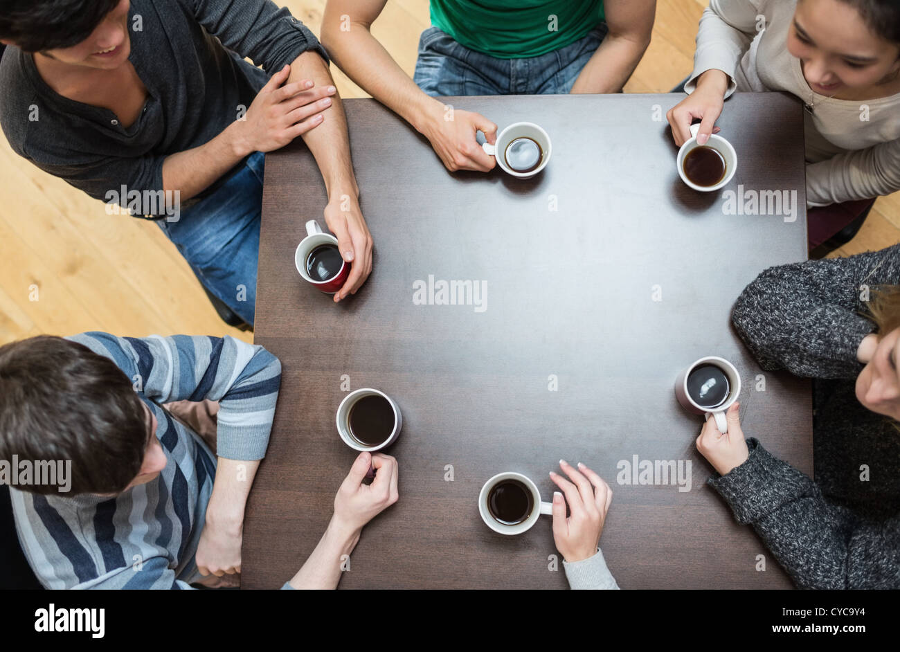 People sitting around table drinking coffee Stock Photo - Alamy
