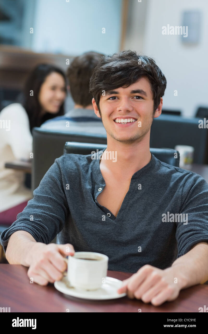 Man sitting at table drinking coffee Stock Photo - Alamy