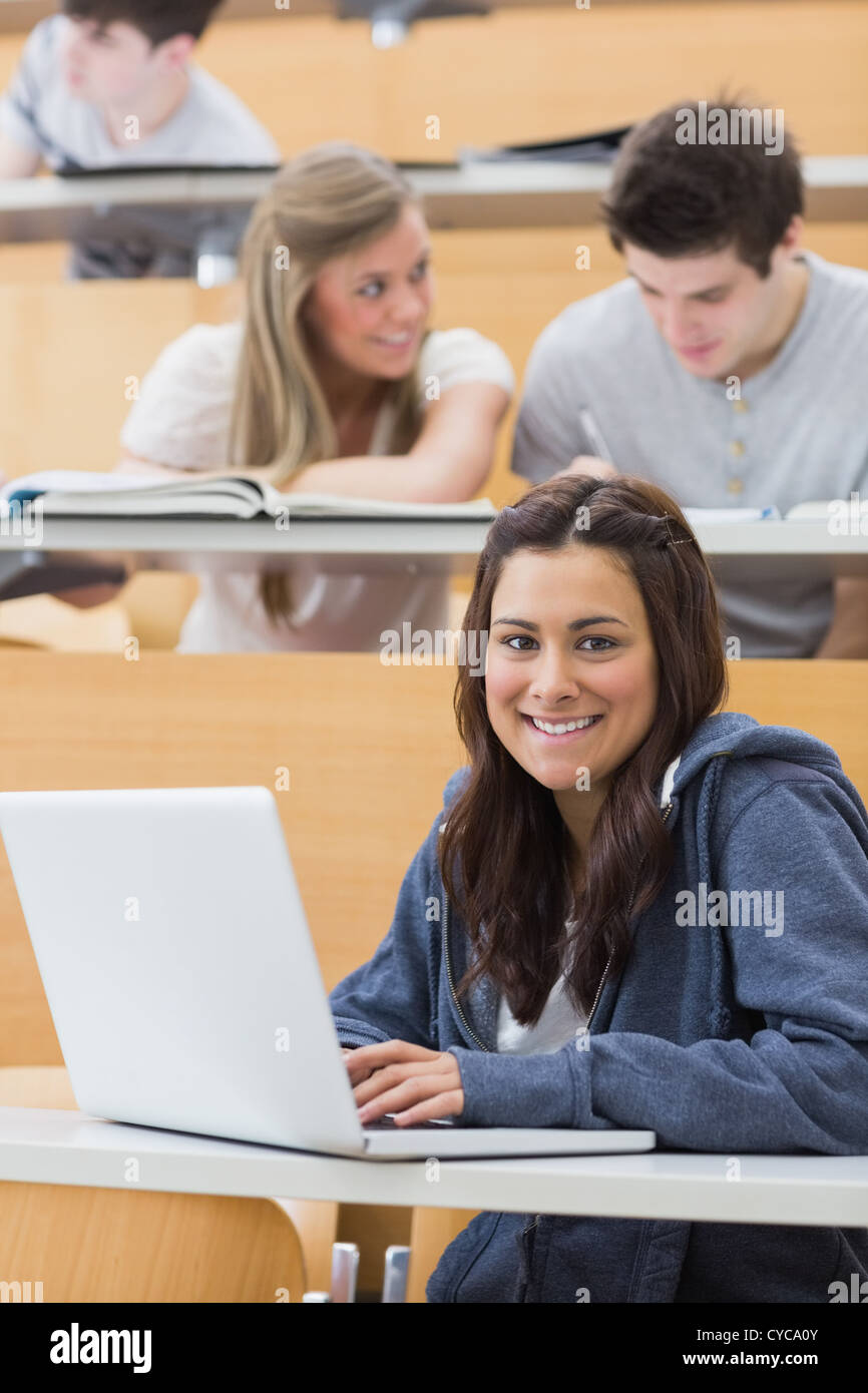 Girl sitting at the lecture hall with laptop Stock Photo - Alamy