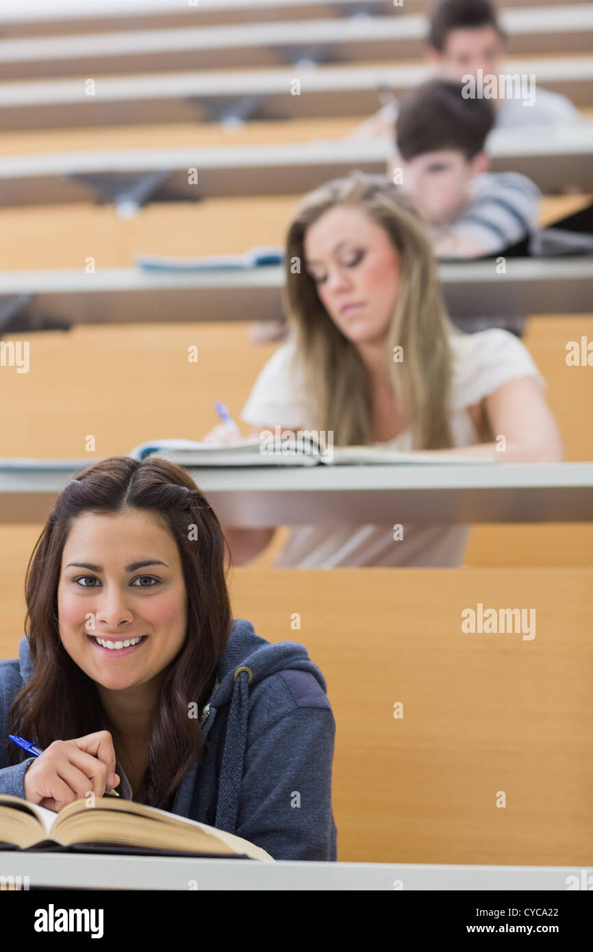 Student sitting reading a book in lecture hall Stock Photo - Alamy