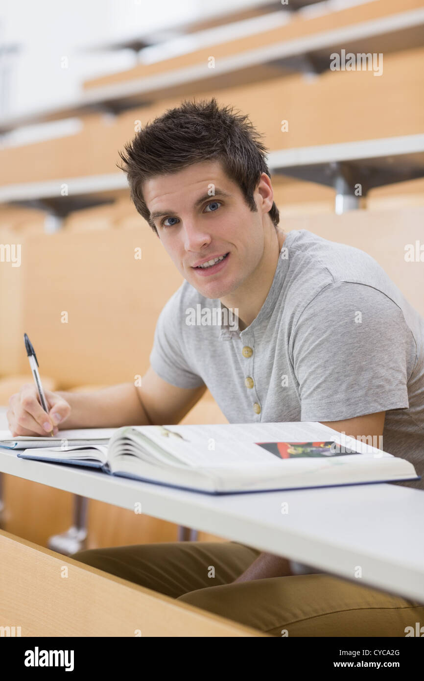 Student smiling while sitting and taking notes Stock Photo - Alamy