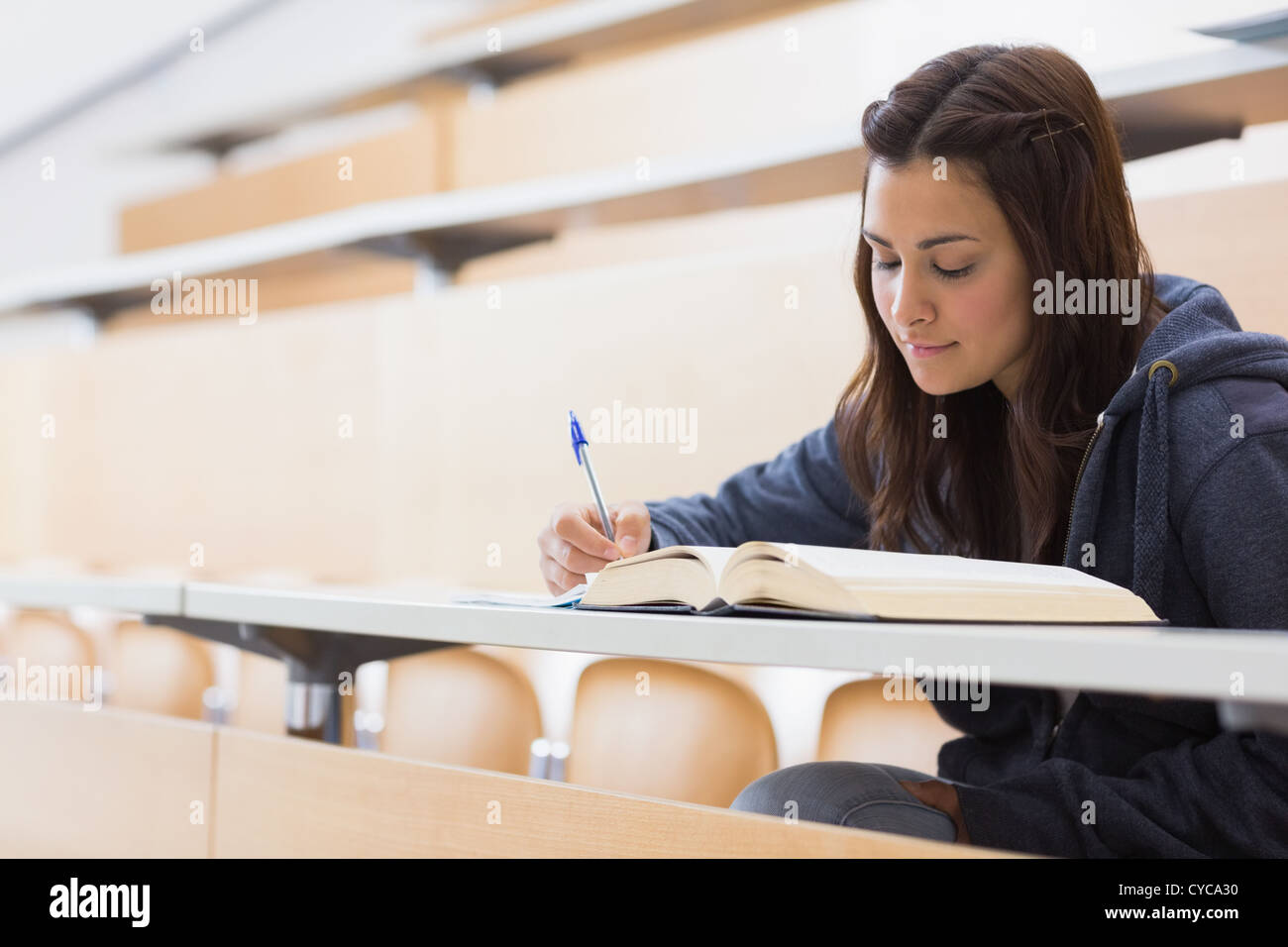 Girl reading a book and writing notes Stock Photo - Alamy
