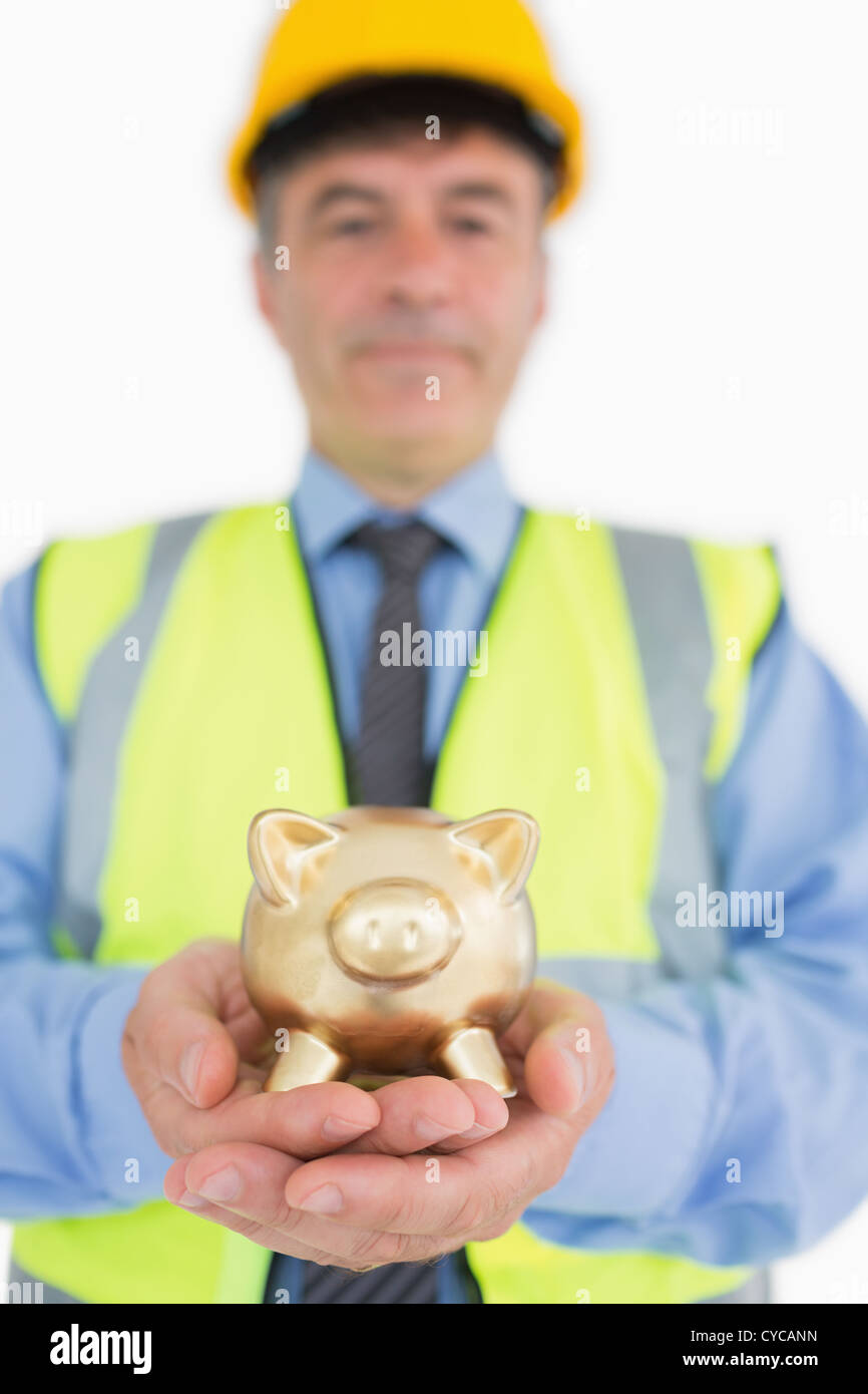 Smiling architect holding piggy bank Stock Photo - Alamy Smiling architect holding piggy bank Stock Photo - Alamy