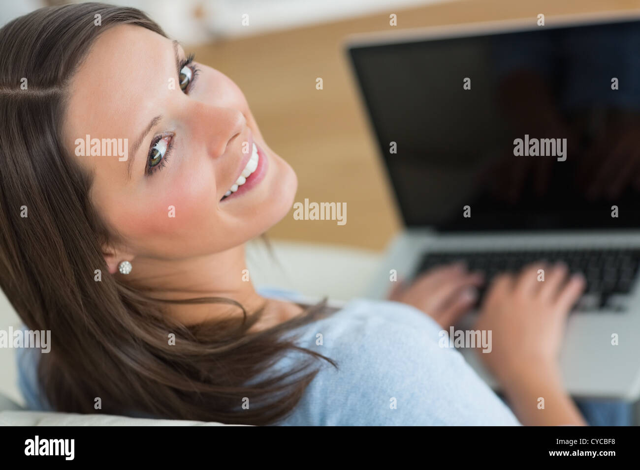 Brunette looking up from using laptop Stock Photo - Alamy