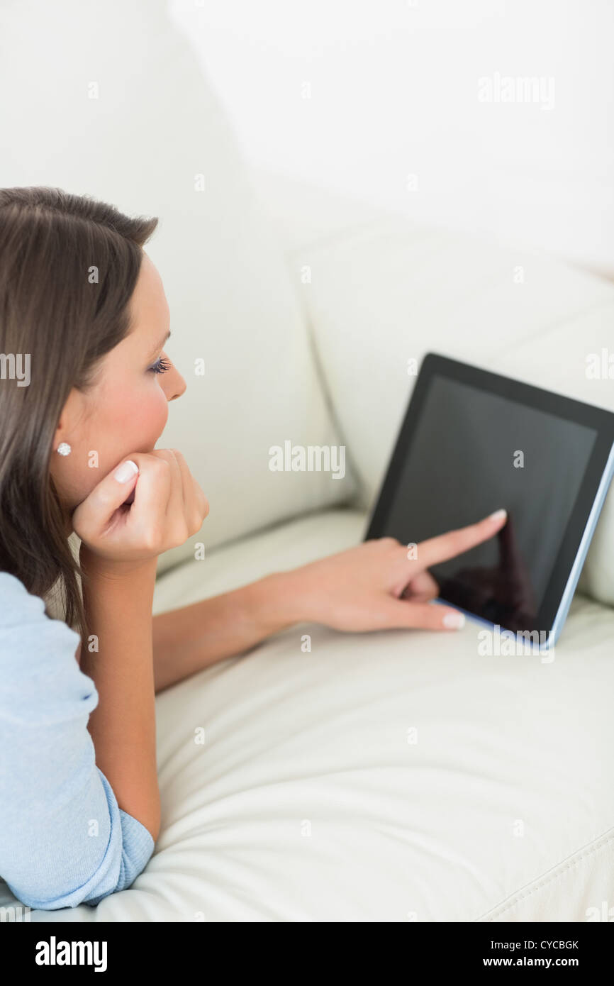 Woman lying on sofa using tablet pc Stock Photo - Alamy
