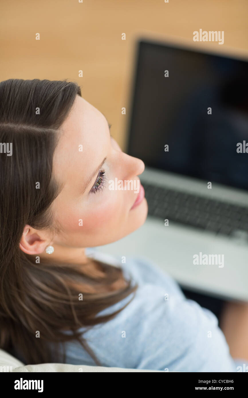 Woman looking away from laptop Stock Photo - Alamy