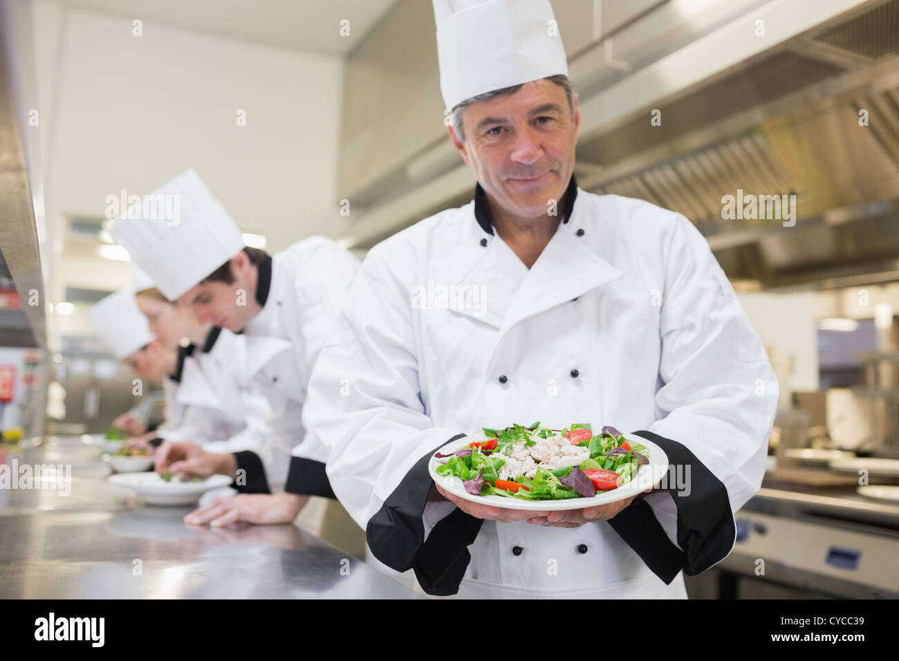 Cheerful chef presenting his salad Stock Photo - Alamy