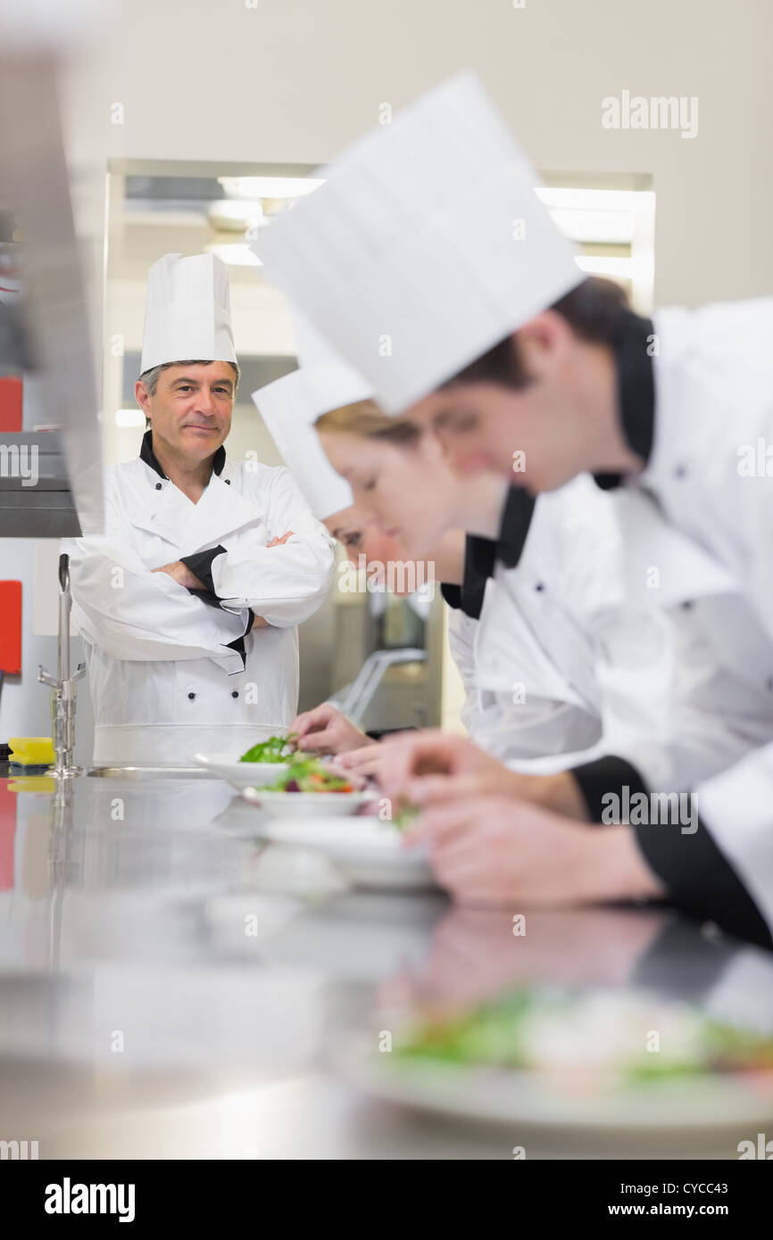 Culinary class making salads as teacher is supervising Stock Photo - Alamy