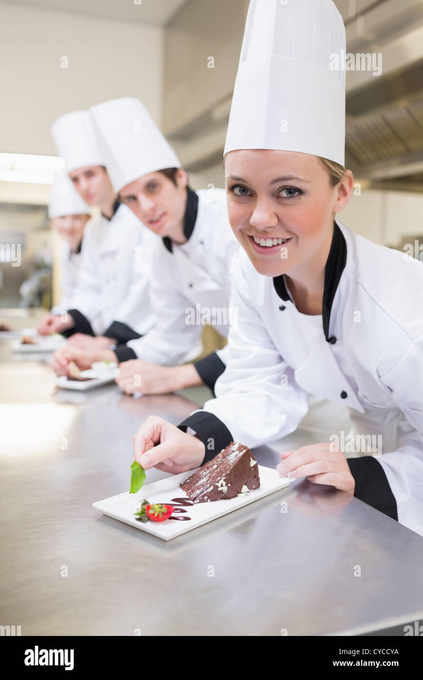 Chef's team preparing slices of cake Stock Photo - Alamy